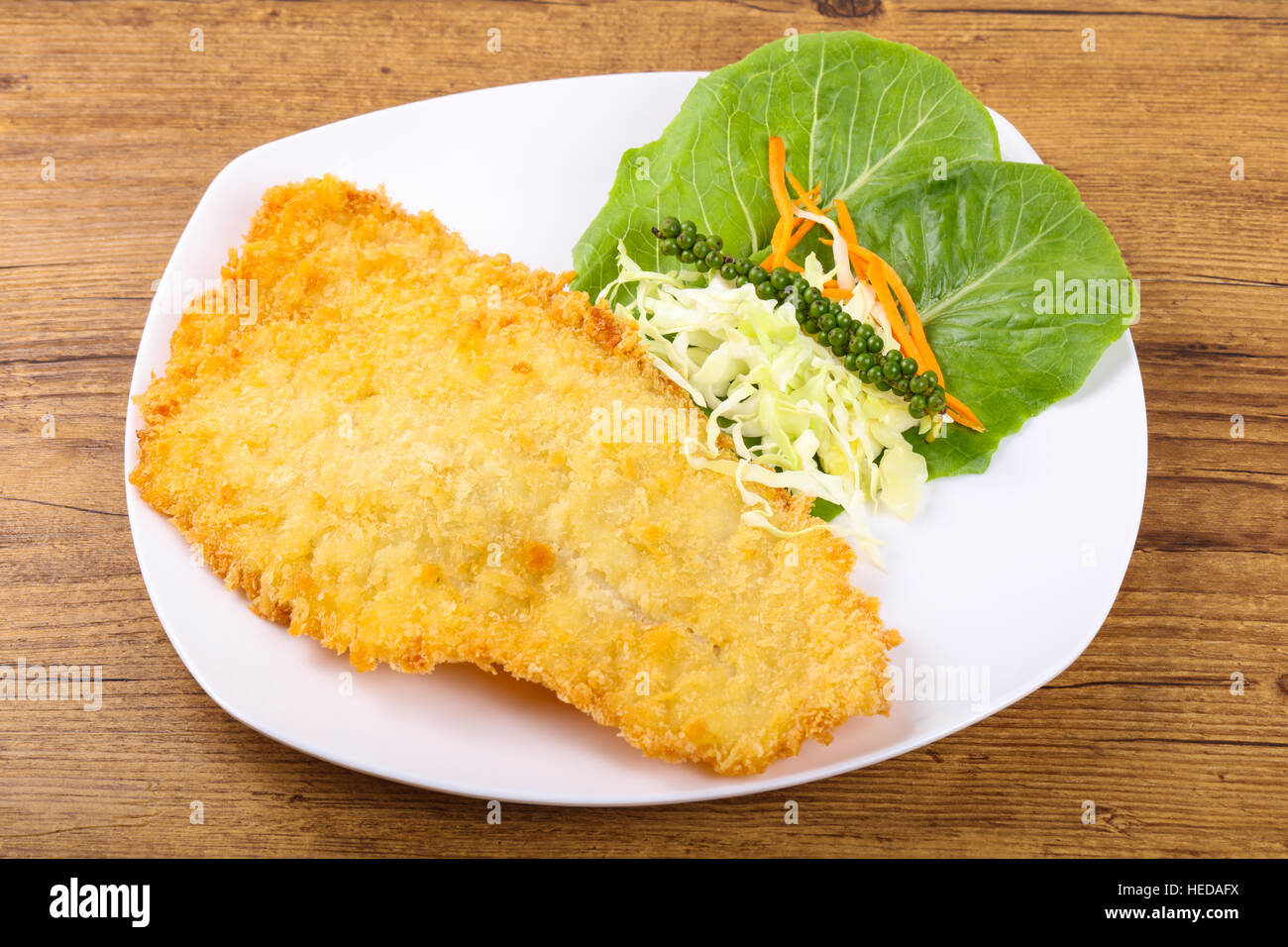 Fried Dory fish with salad on the wood background Stock Photo - Alamy