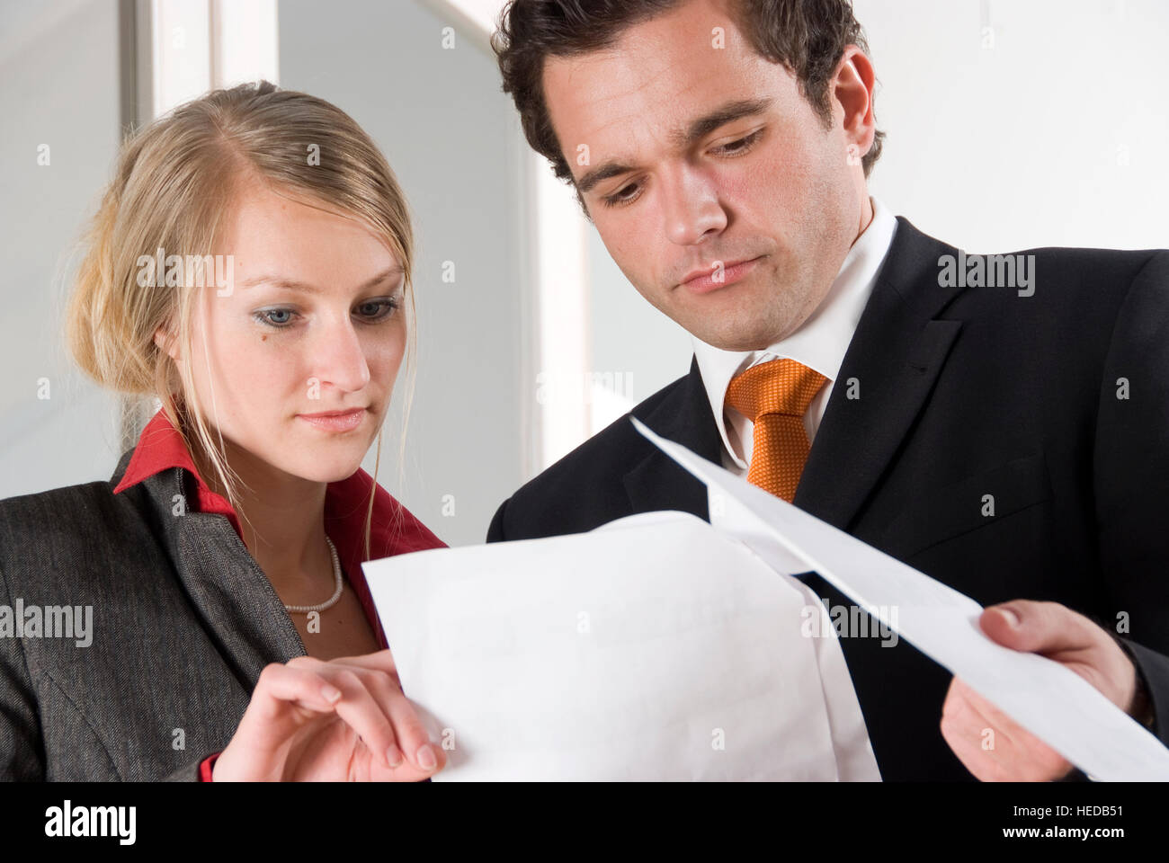 Two young businesspeople looking over documents Stock Photo - Alamy