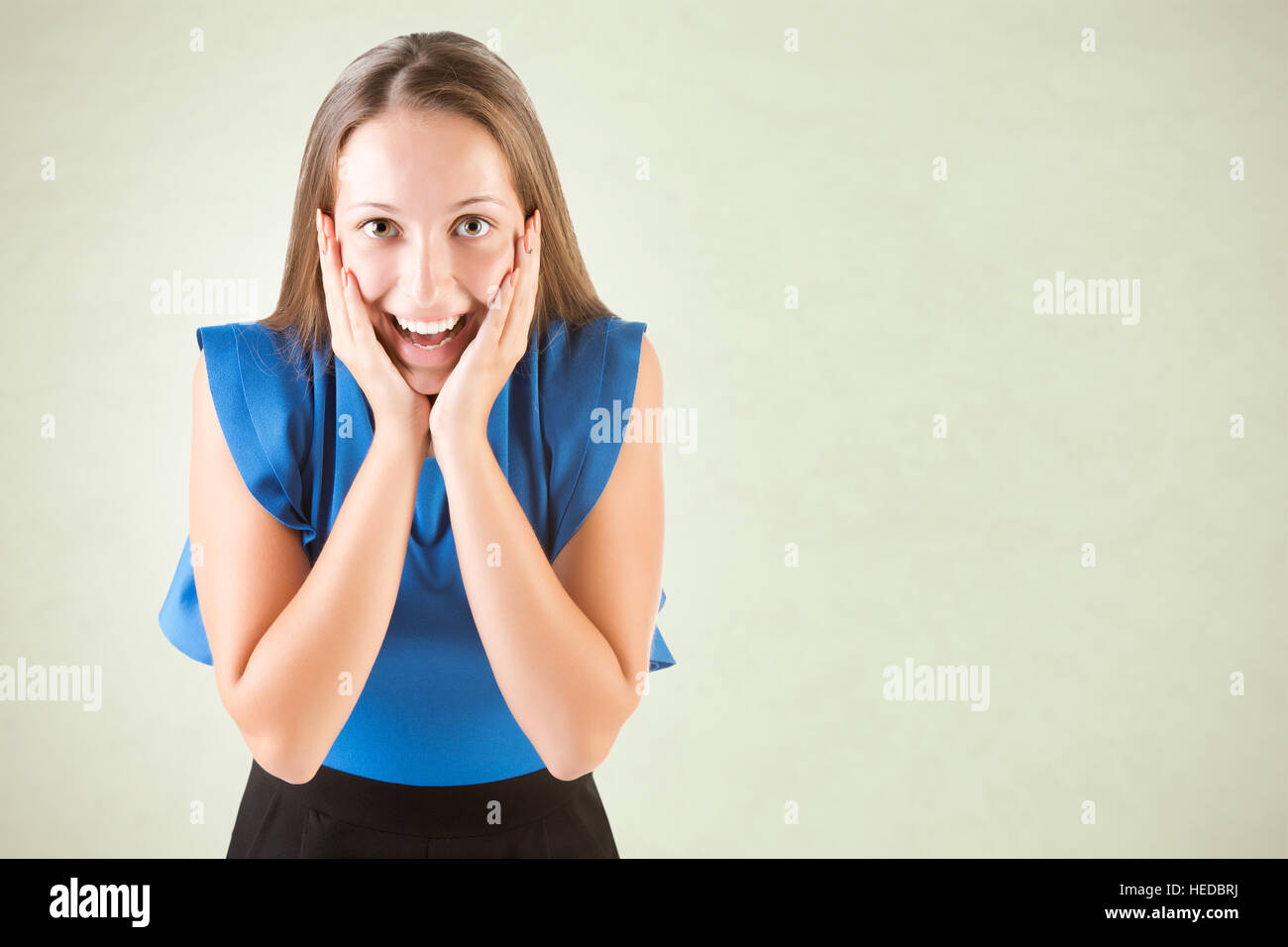 Young woman looking surprised, isolated in a green background Stock ...