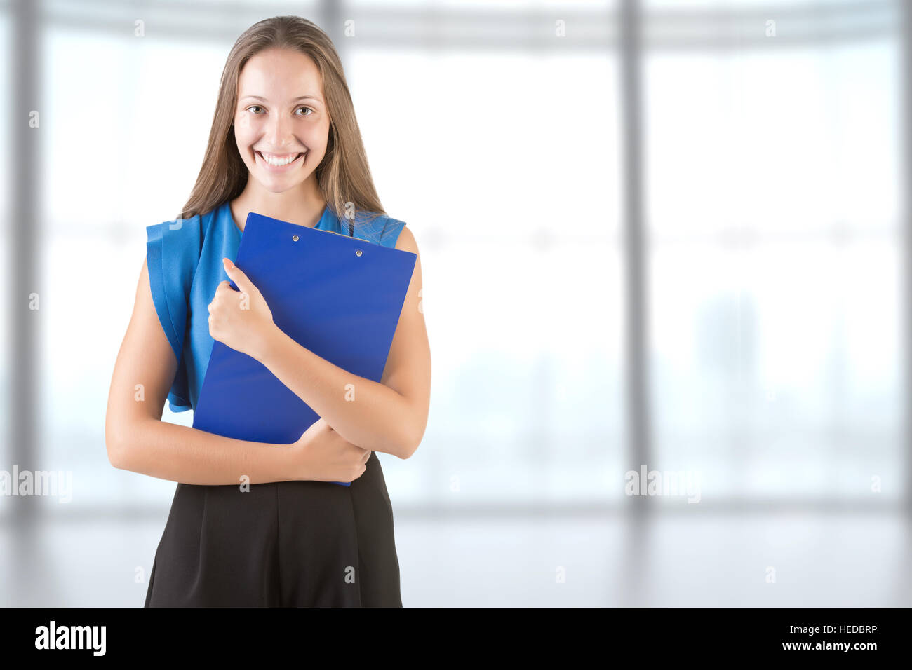 Young woman carrying notebooks in her arms, in a school Stock Photo - Alamy