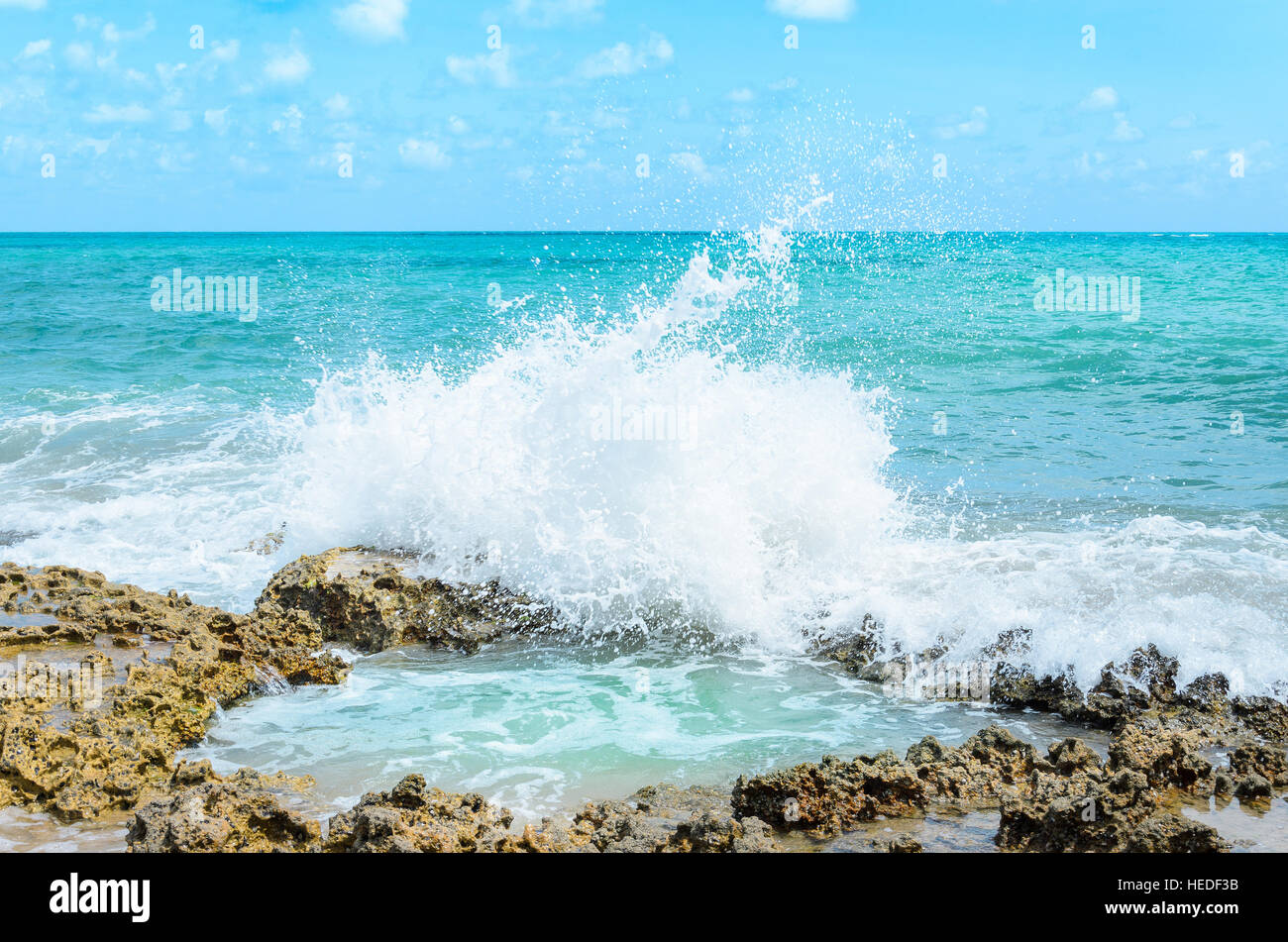 Ocean water splashing on rocks and forming a natural pool in the center ...