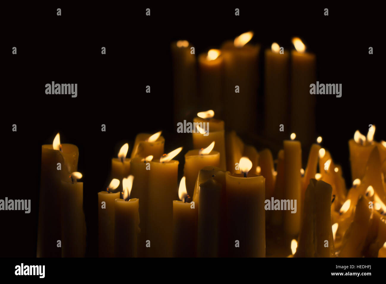 Light many candles burning in the black background Stock Photo - Alamy