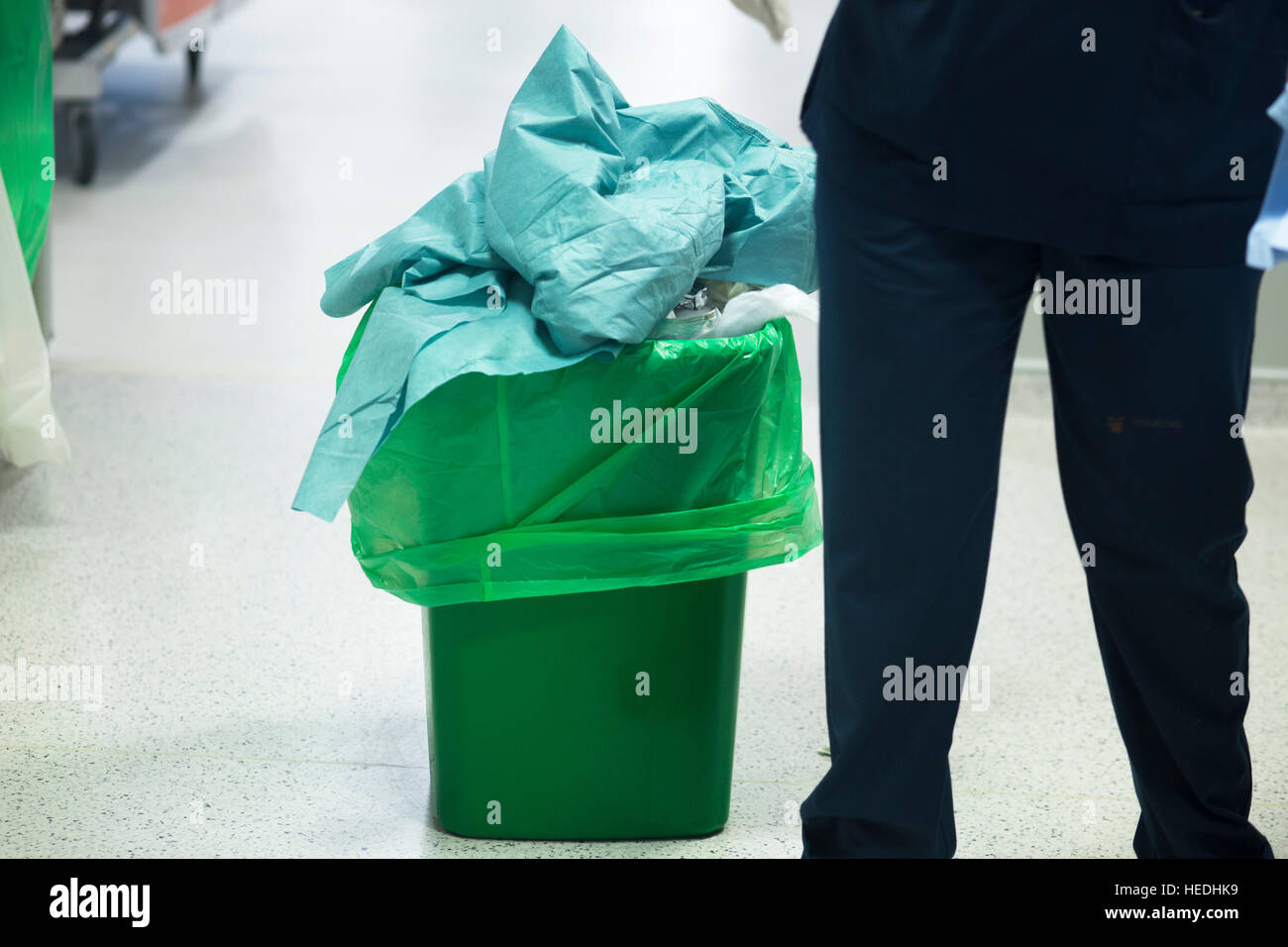 Operating theater surgery trash bin and nurse with green plastic bag ...