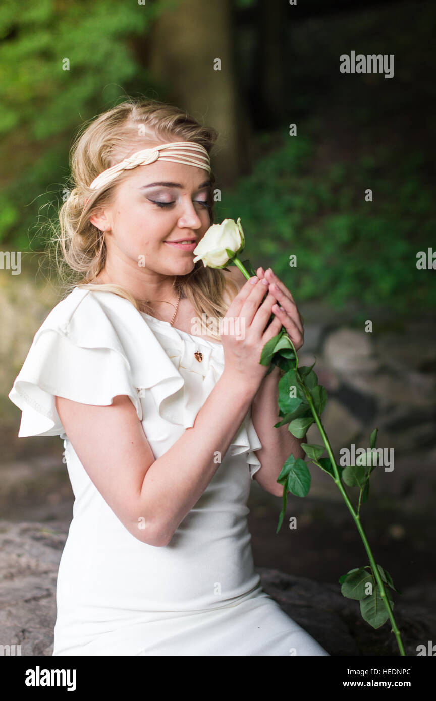 beautiful girl sniffing white rose Stock Photo - Alamy