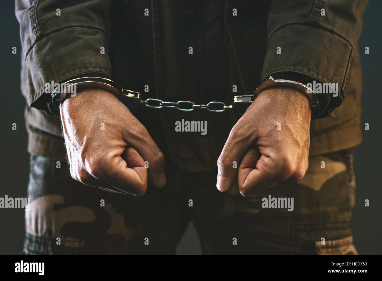 Handcuffed soldier, arrested male army officer in dark prison cell ...