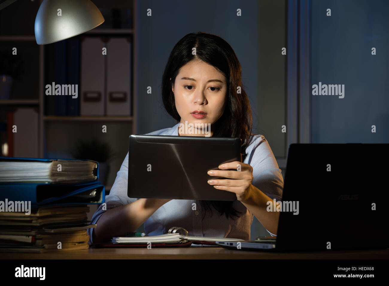 asian business woman touch screen on digital tablet working overtime ...