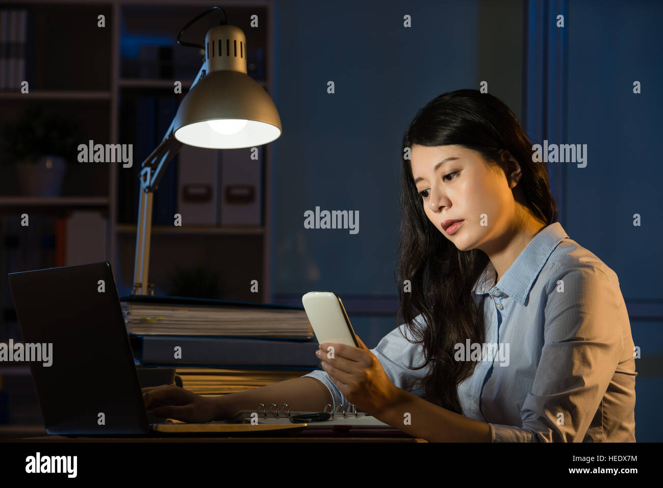 asian business woman text message by smartphone working overtime late ...