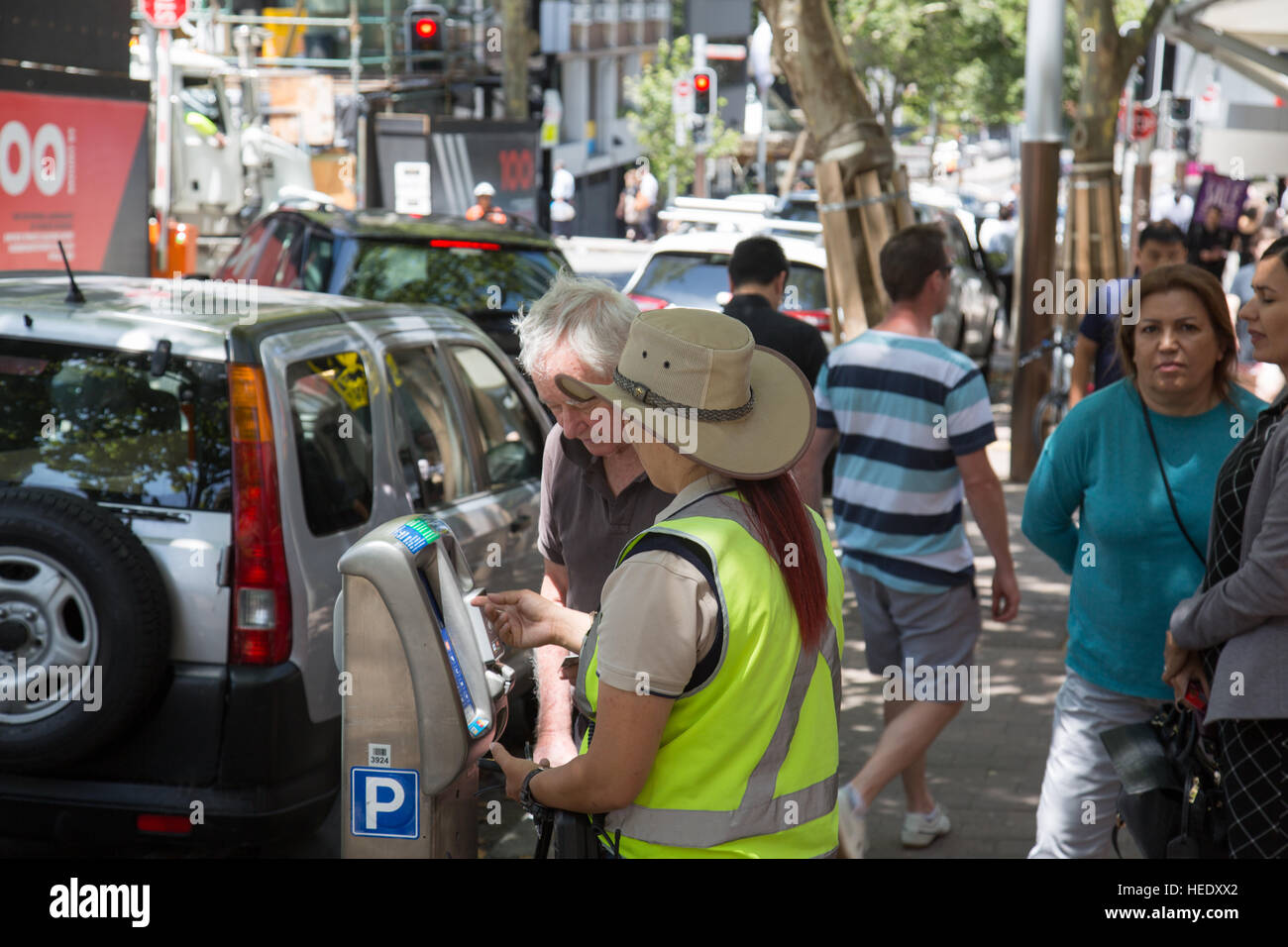 Female Council Ranger helps a motorist operate the parking payment ...