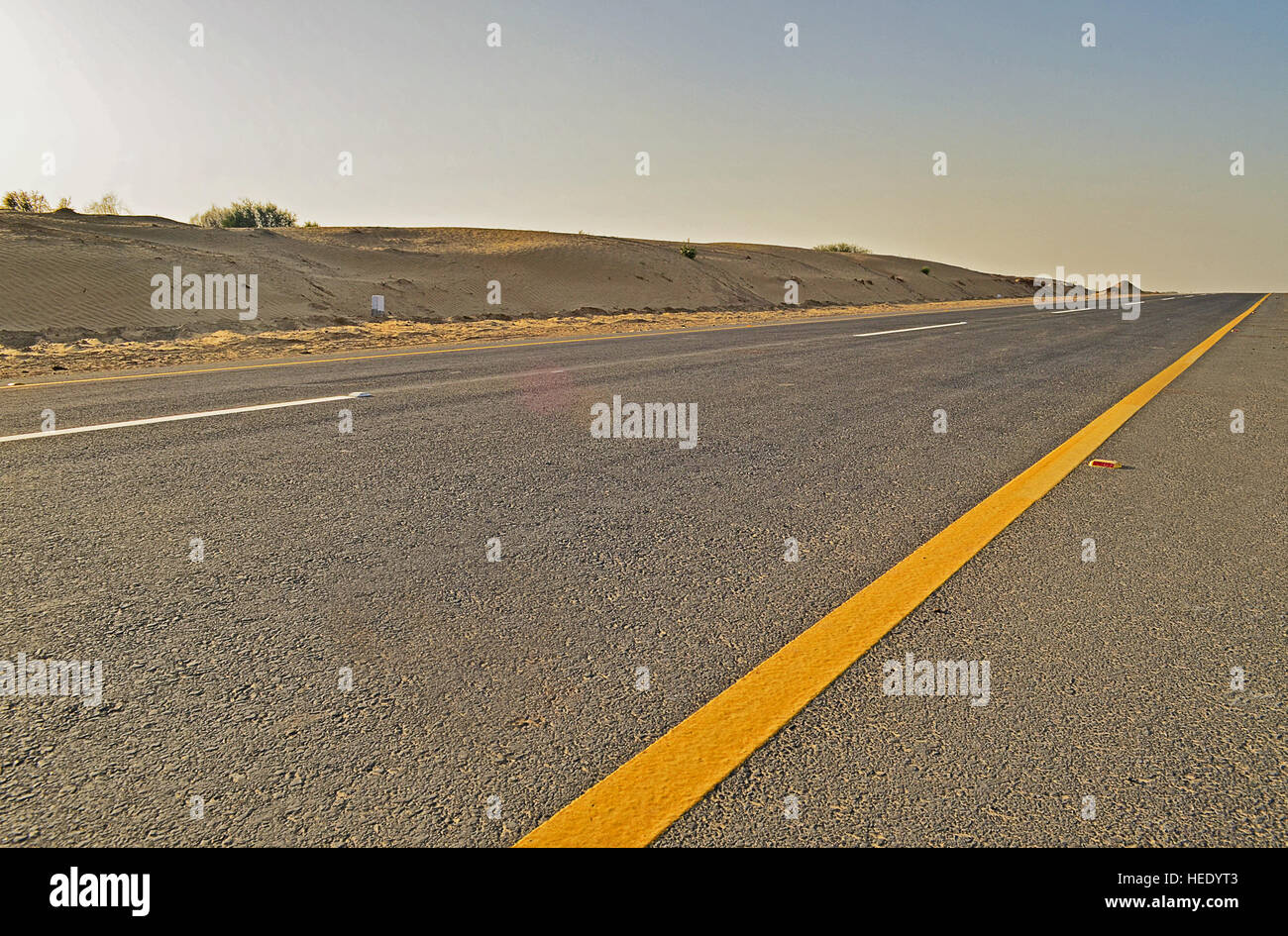 An empty road in a desert terrain Stock Photo - Alamy