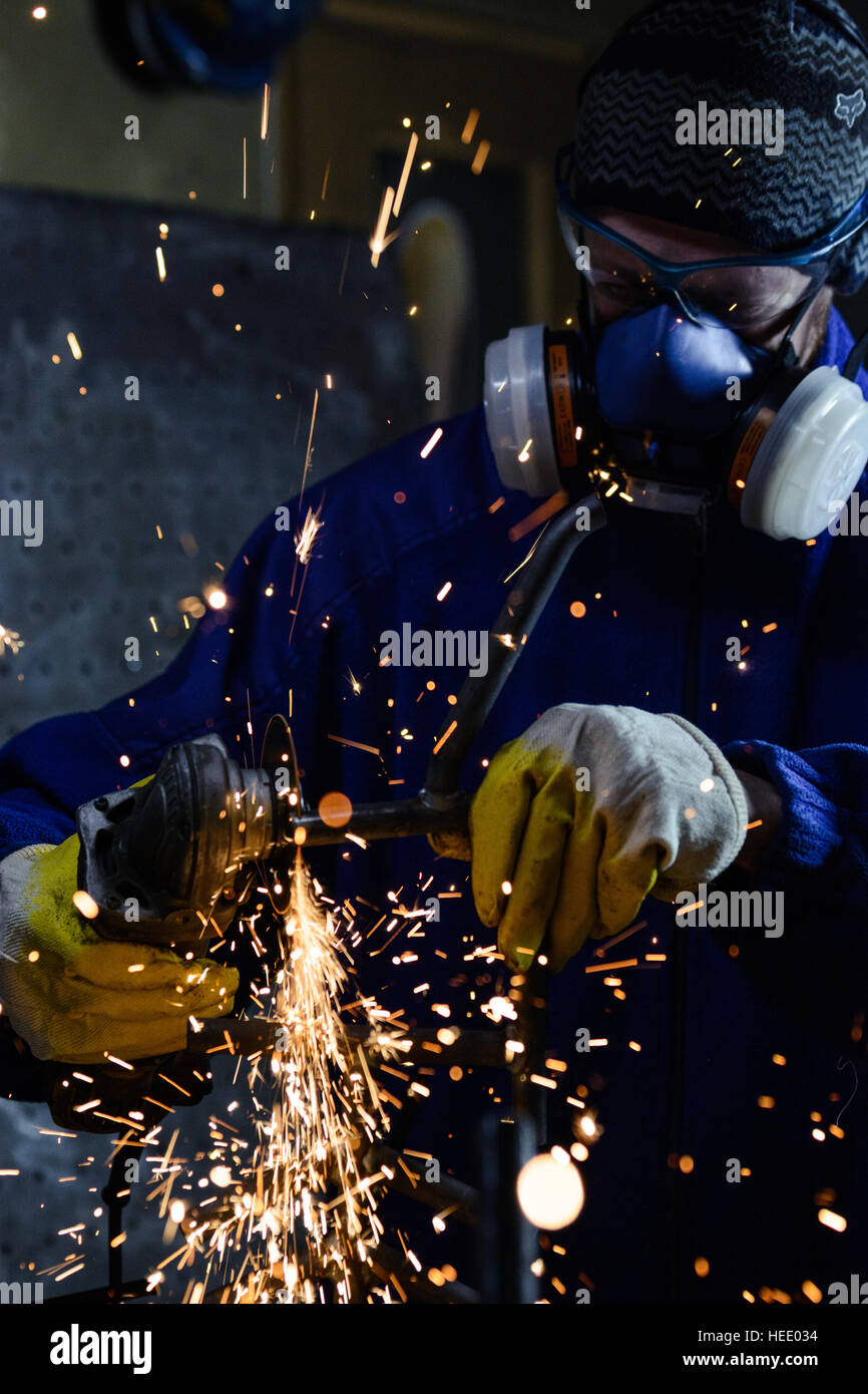Man cutting metal with a circular grinder and producing hot sparks in ...