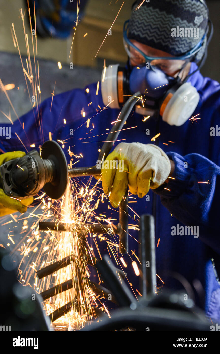 Man grinding metal with hot sparks in an industrial workshop Stock ...