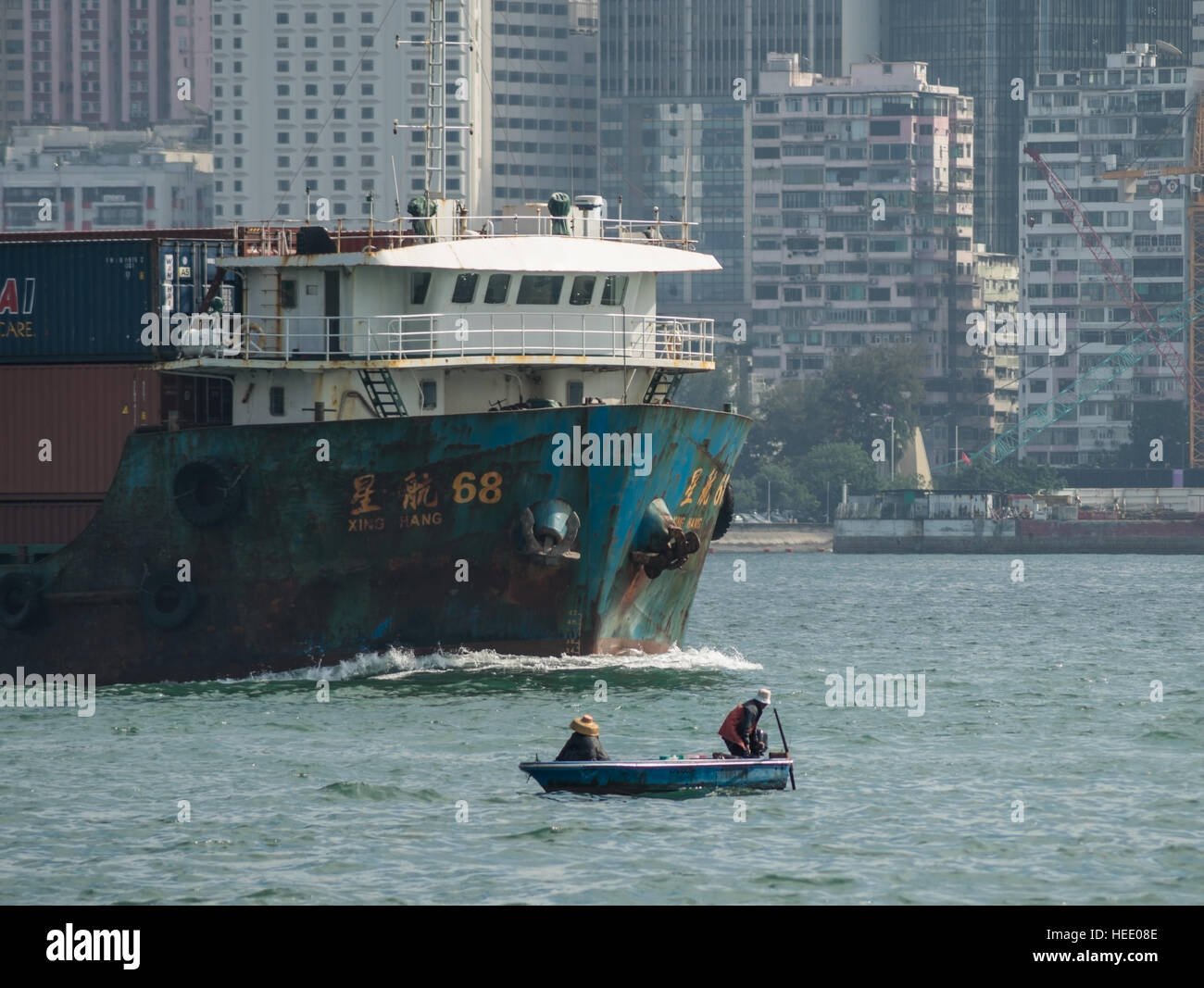 Big and small: large ship approaching small boat in Hong Kong SAR Stock ...