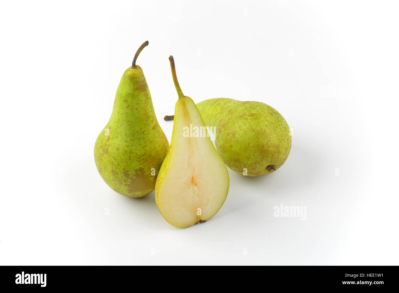two whole fresh green pears and one half Stock Photo - Alamy