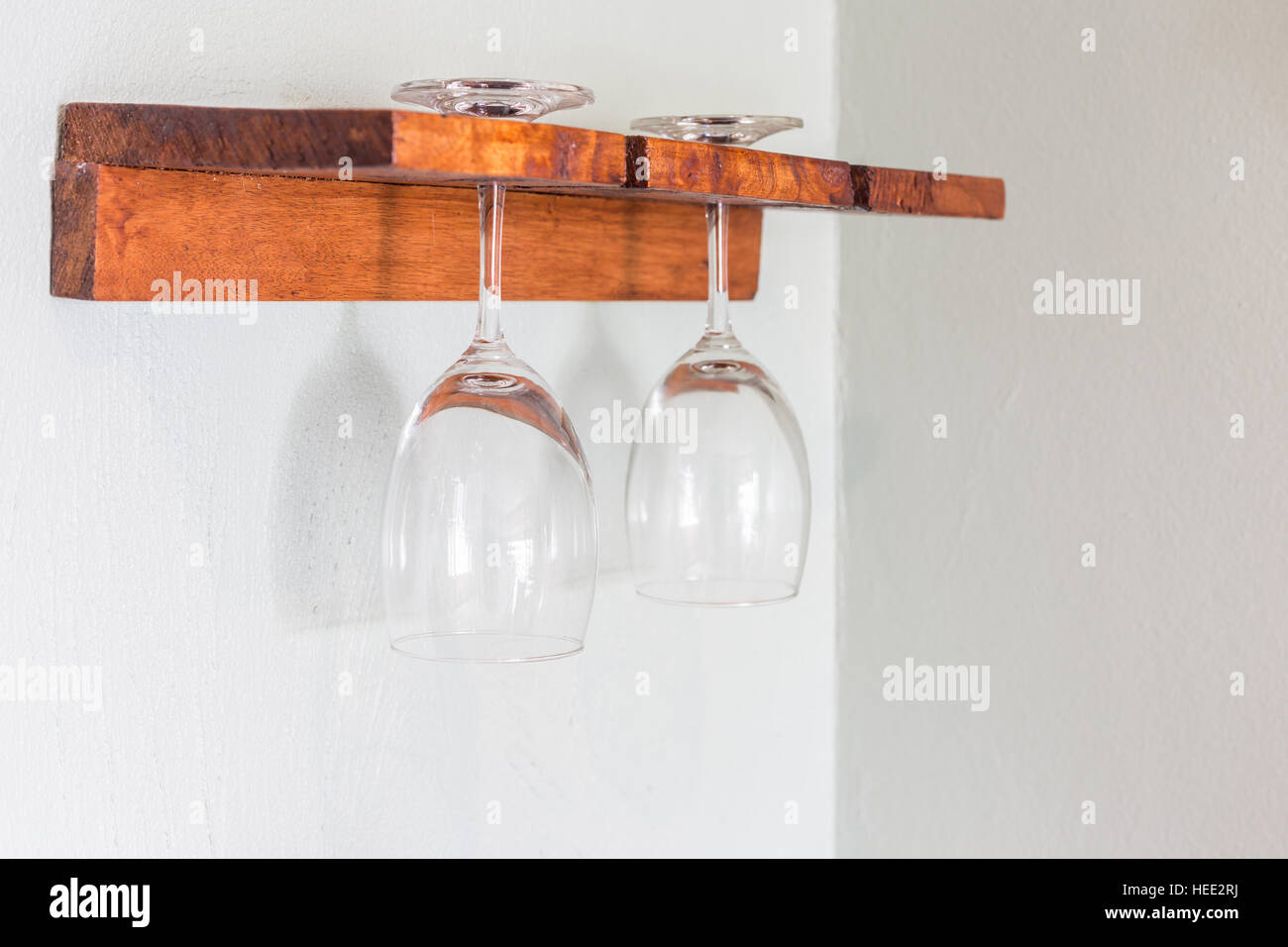 Two of wine glasses place on the wooden rack Stock Photo - Alamy