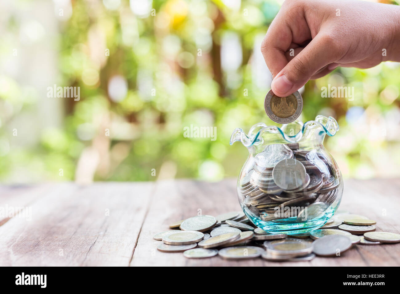 Close up hand putting coins in money jar. savings concept Stock Photo ...