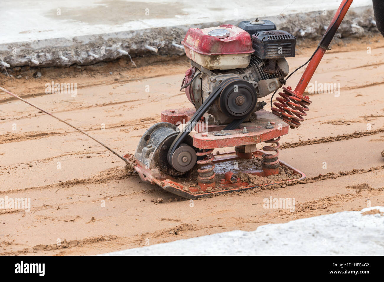 Worker with soil compactors in construction site Stock Photo - Alamy