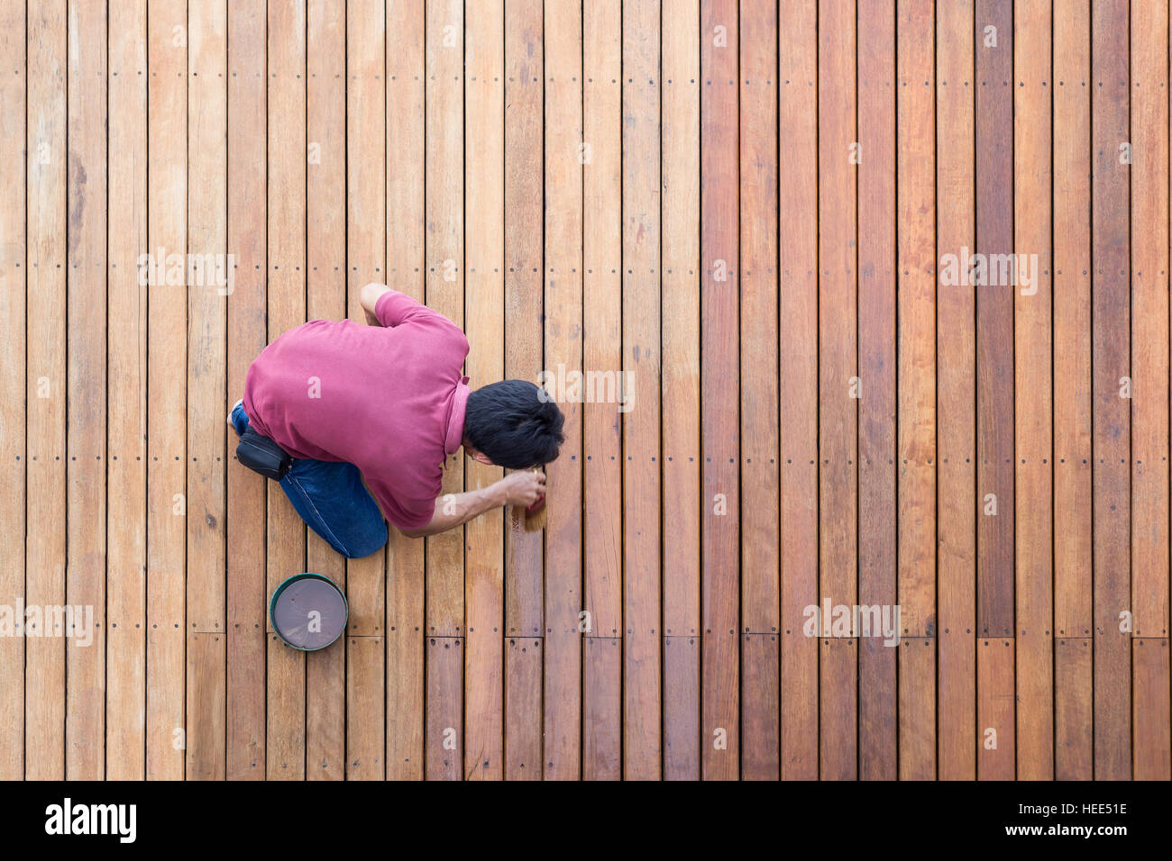A worker painting exterior wooden pool deck, Top view Stock Photo - Alamy