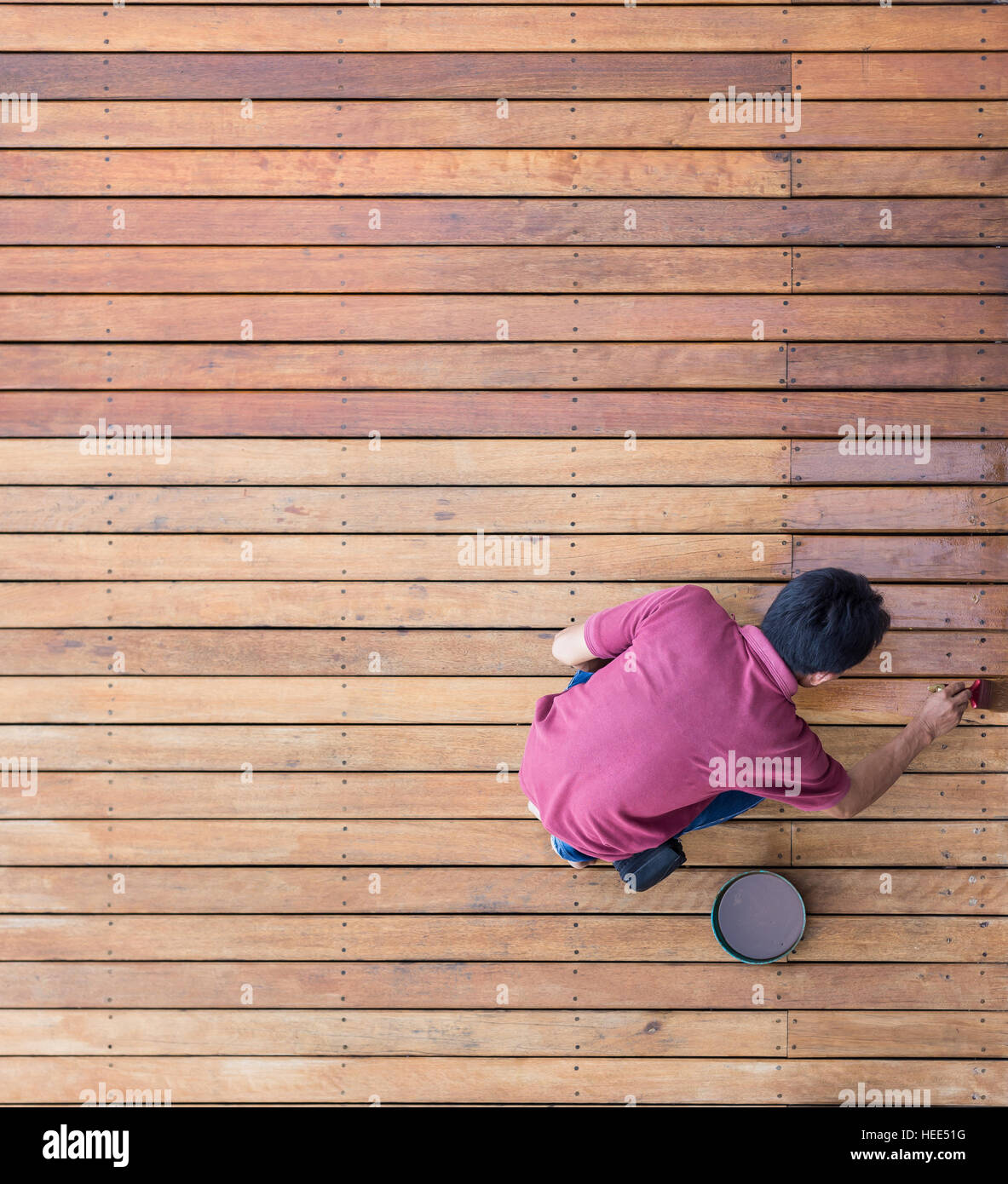A worker painting exterior wooden pool deck, Top view Stock Photo - Alamy