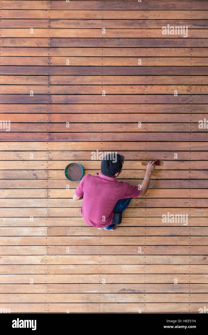 A worker painting exterior wooden pool deck, Top view Stock Photo - Alamy