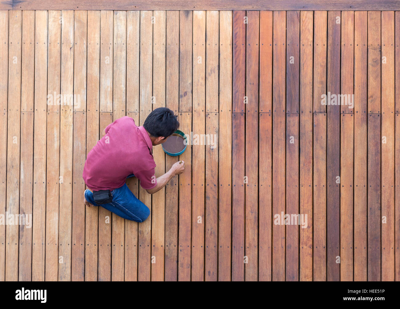 A worker painting exterior wooden pool deck, Top view Stock Photo - Alamy