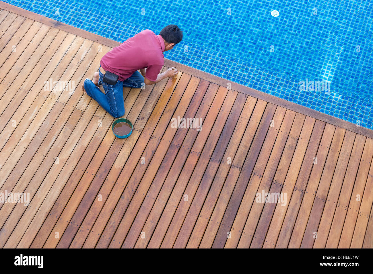 A worker painting exterior wooden pool deck, Top view Stock Photo - Alamy