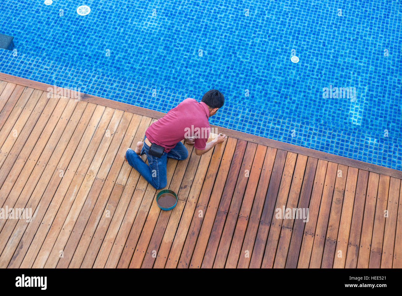 A worker painting exterior wooden pool deck, Top view Stock Photo - Alamy