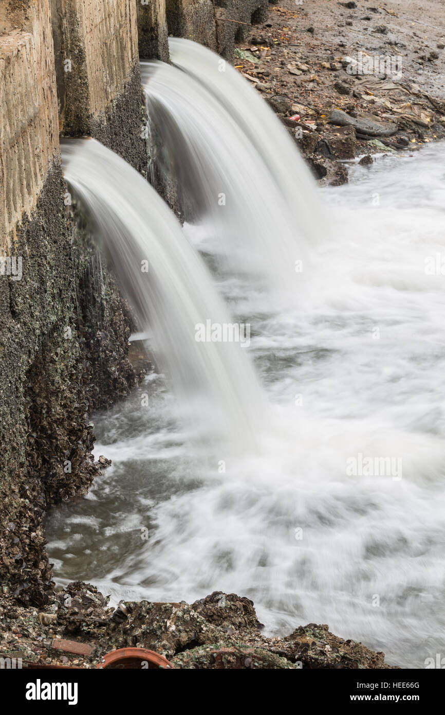 Water flowing from drain to the river Stock Photo - Alamy