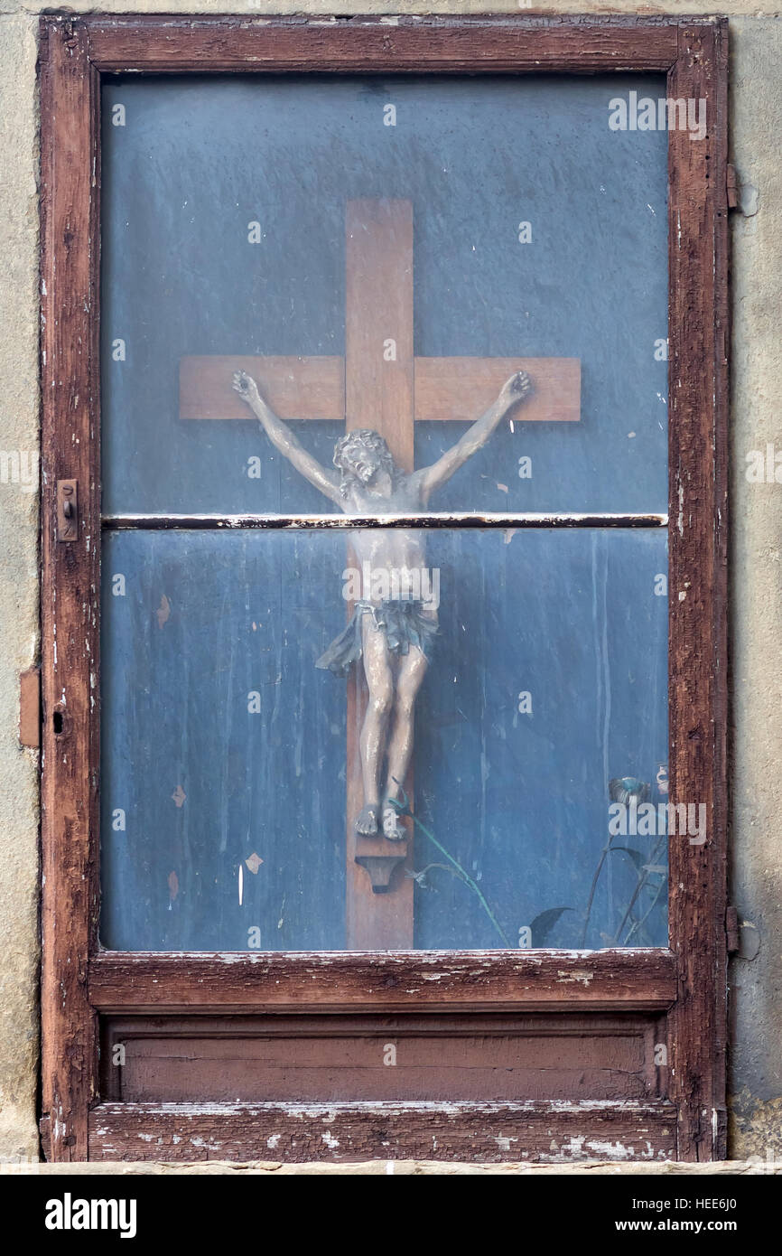 Jesus on the cross behind a window at an old house in Florence, Italy ...