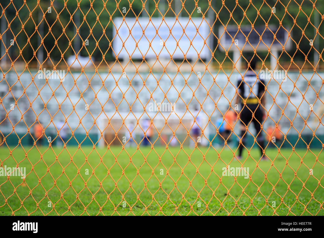 Orange soccer net and blur of player in stadium Stock Photo - Alamy