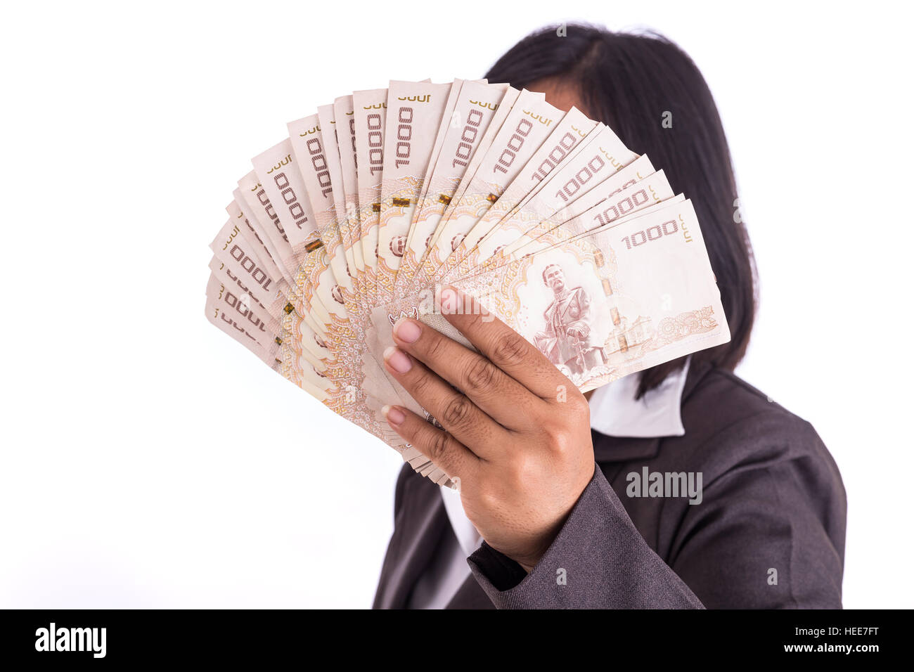 Woman holding Thai money hide her face isolated on white background ...