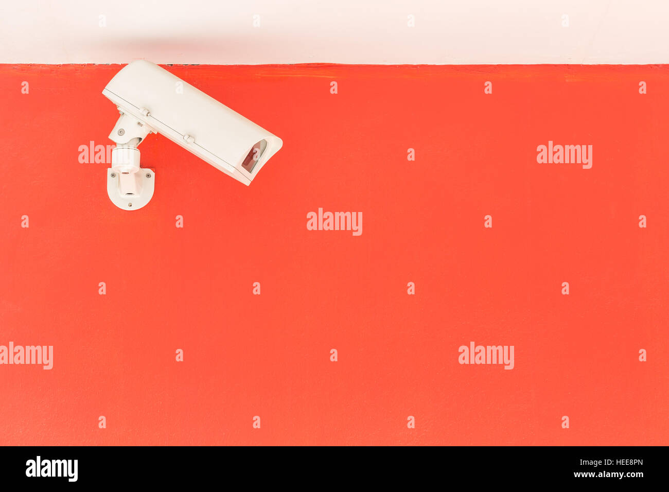 White security CCTV camera operating on the red building wall Stock ...