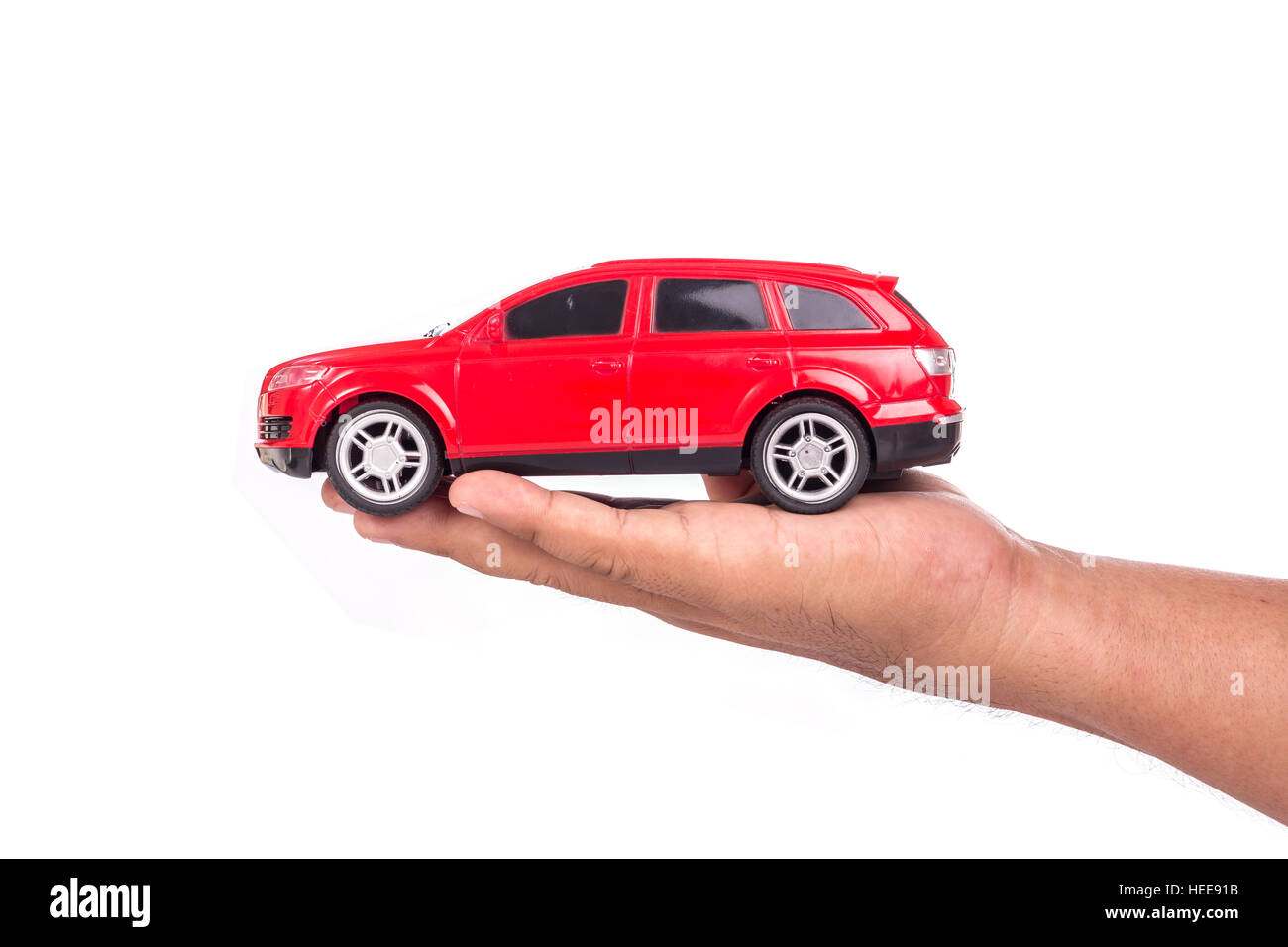 Hand holding red model car isolated on white background Stock Photo - Alamy