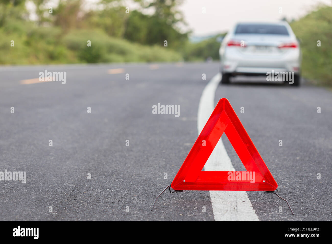 Red emergency stop sign and broken silver car on the road Stock Photo ...