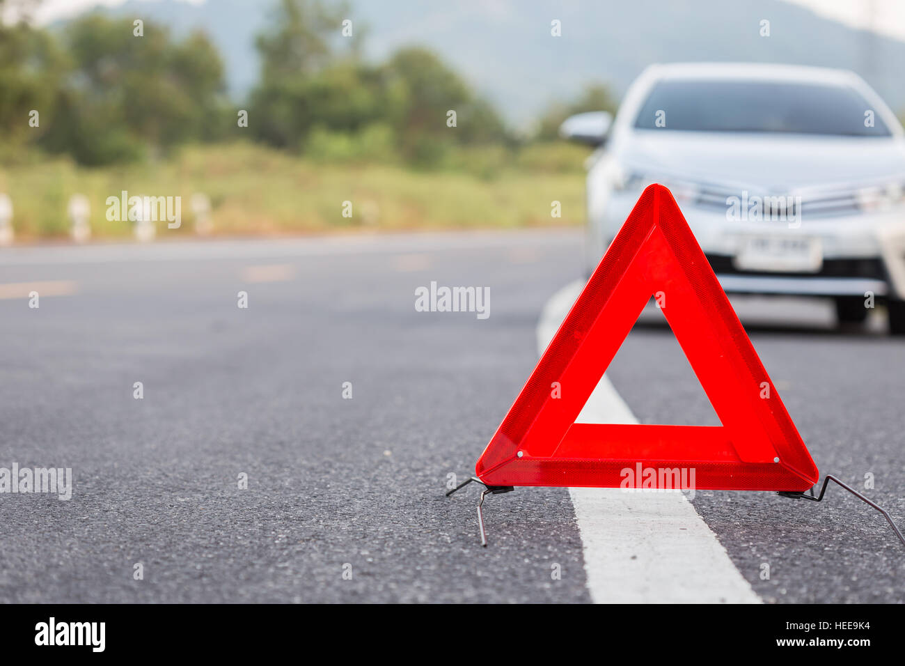Red emergency stop sign and broken silver car on the road Stock Photo ...