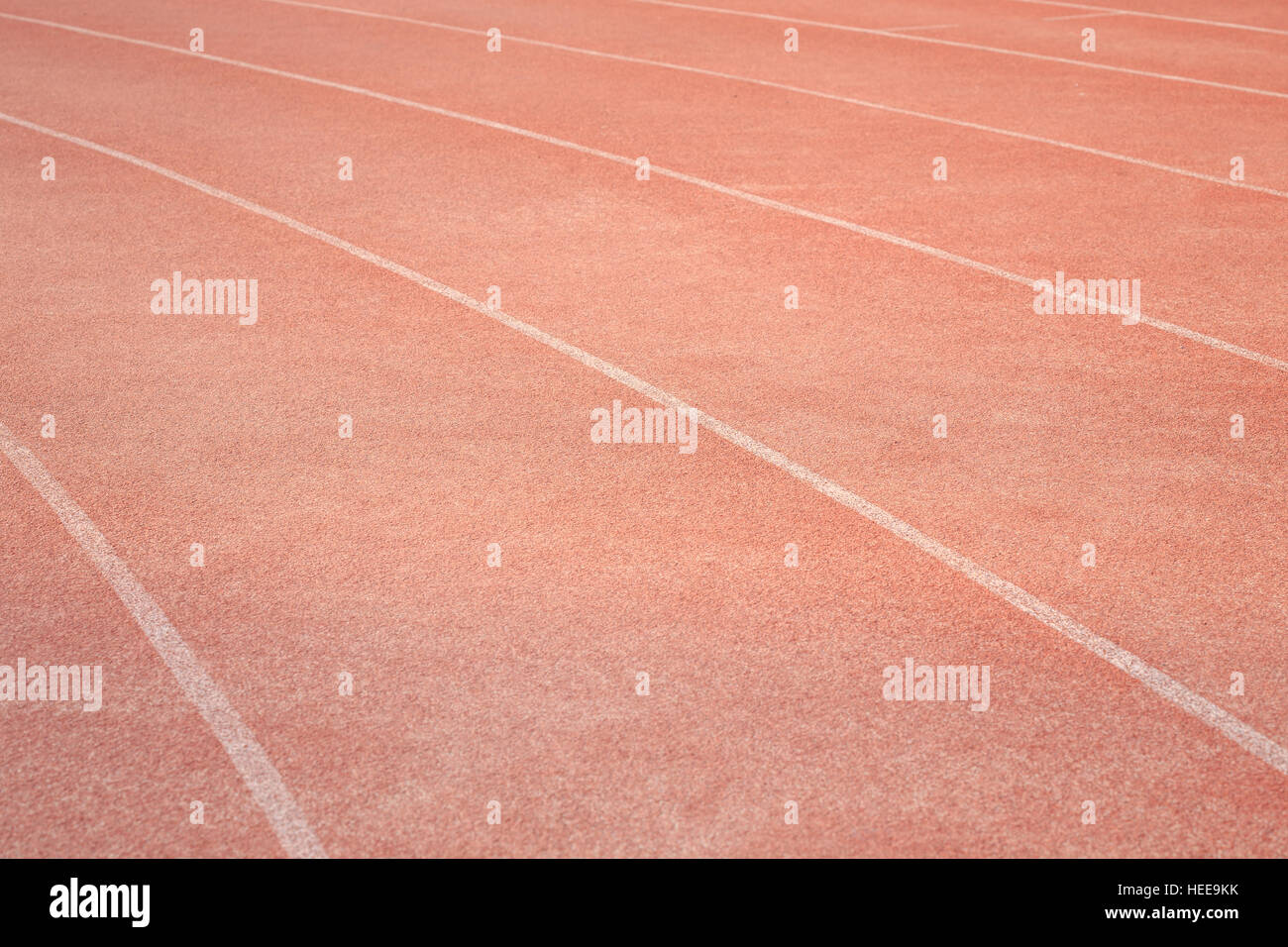 Old red running track with white stripe Stock Photo - Alamy