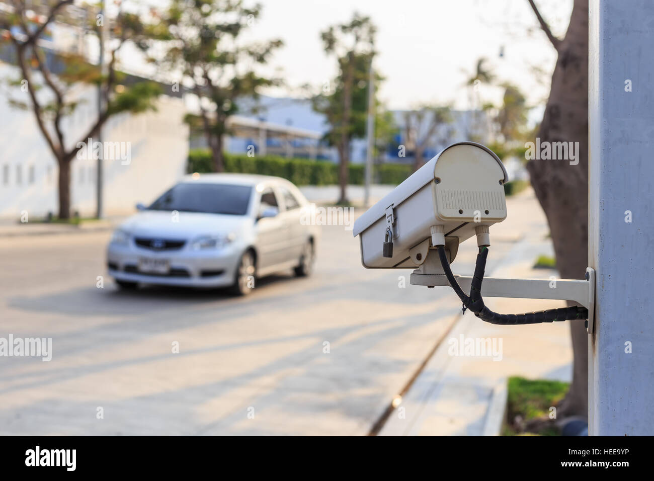 Close up Security CCTV camera operating on the road and blurred of car ...