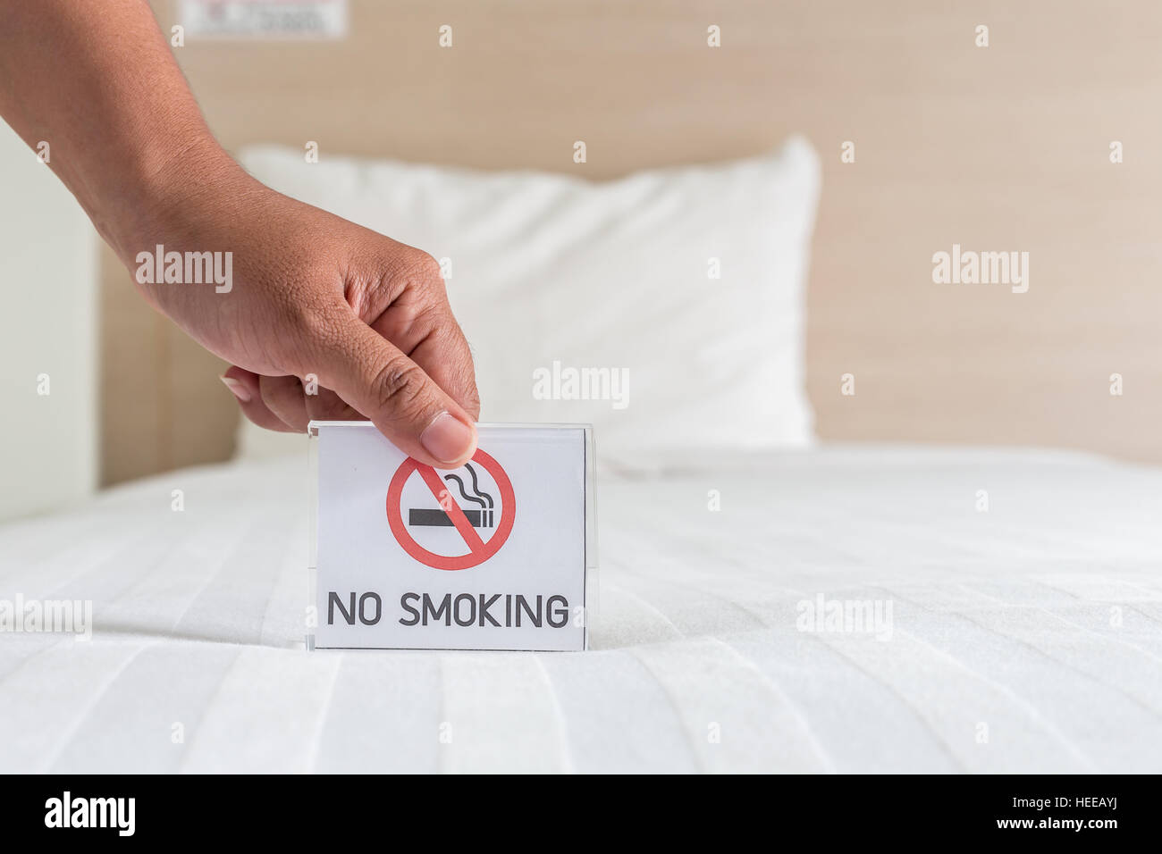 Close up hand holding NO SMOKING sign on the bed in hotel room Stock ...