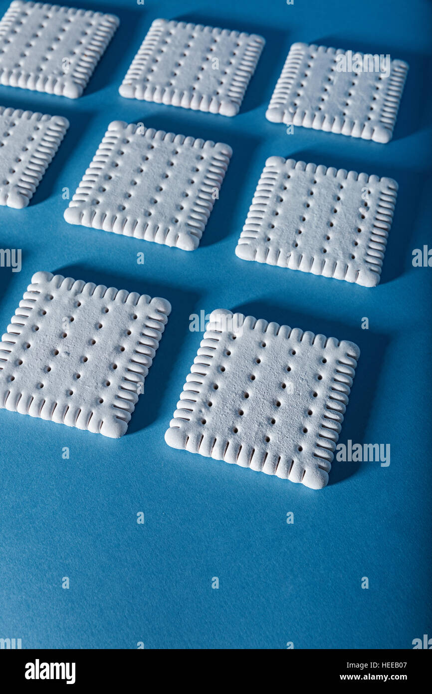 Closeup of white square cookies over blue background Stock Photo - Alamy
