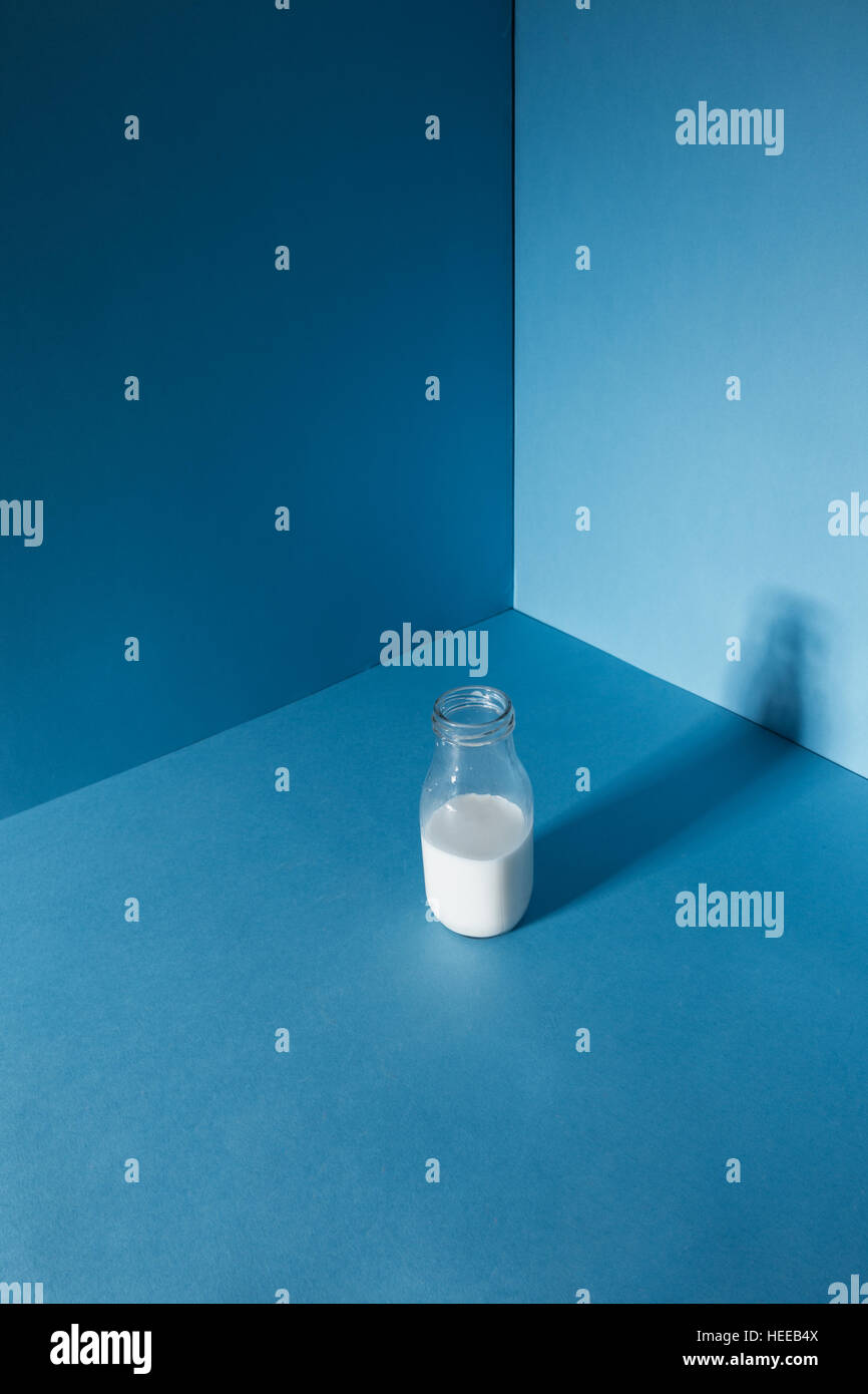 Bottle of fresh milk standing in the corner over blue background Stock ...