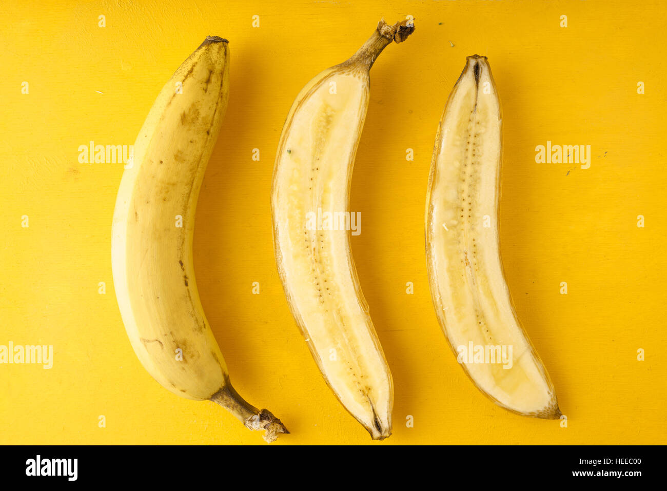 Bananas on a yellow background horizontal Stock Photo - Alamy