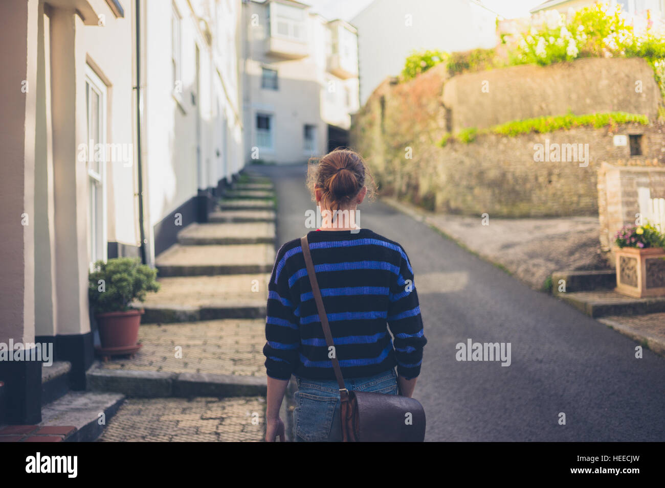 A young woman is walking in a small town Stock Photo - Alamy