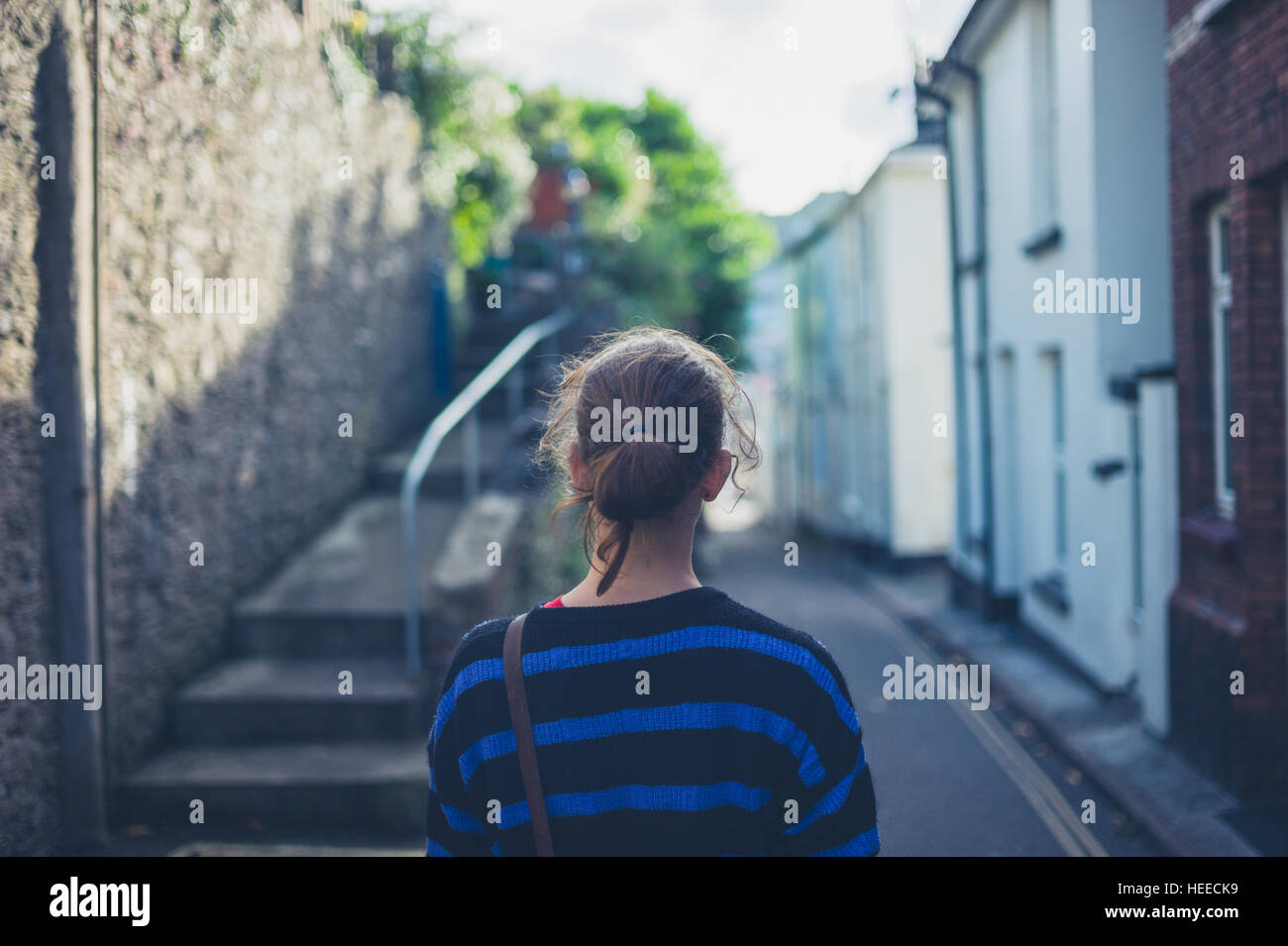 A young woman is walking in a small town Stock Photo - Alamy