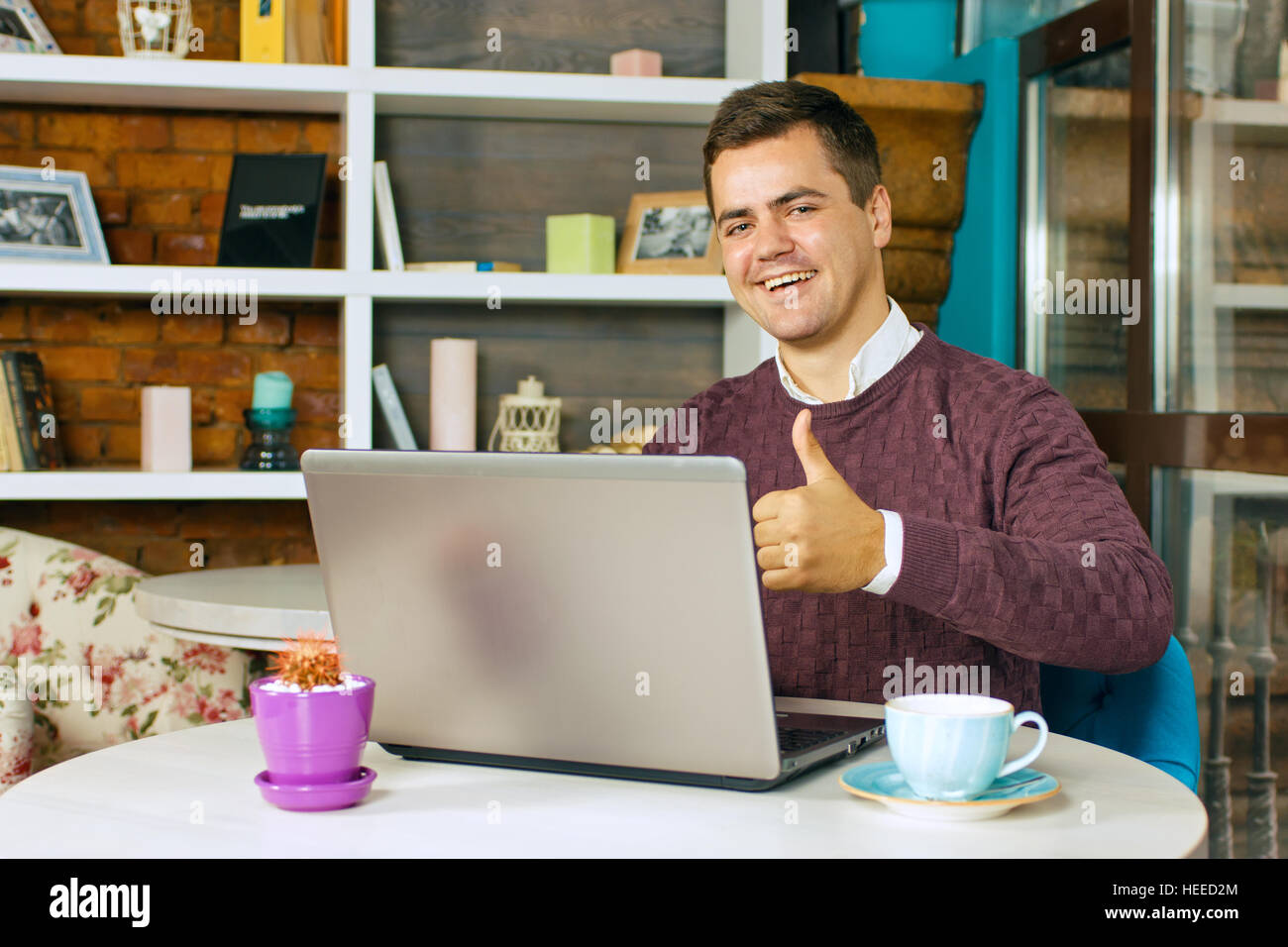 Man in a cafe with laptop smiling Stock Photo - Alamy