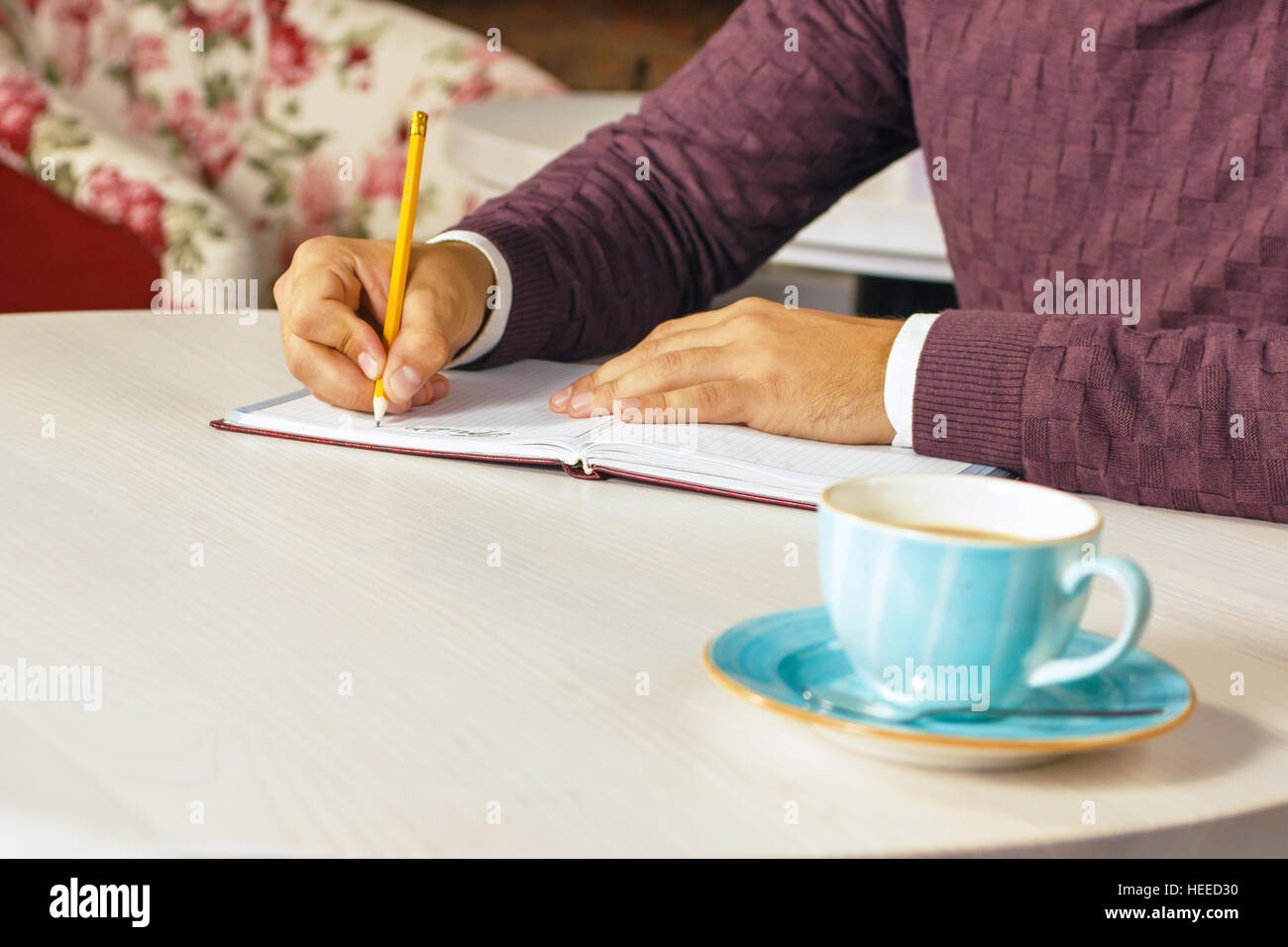Man holding pencil and writing on a paper in the diary Stock Photo - Alamy