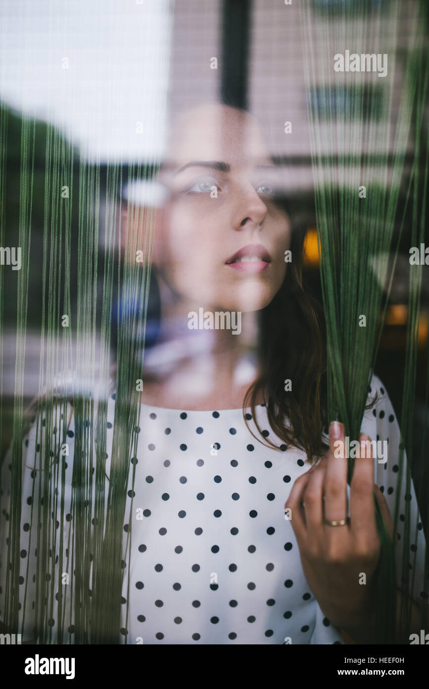 Woman standing behind window Stock Photo - Alamy