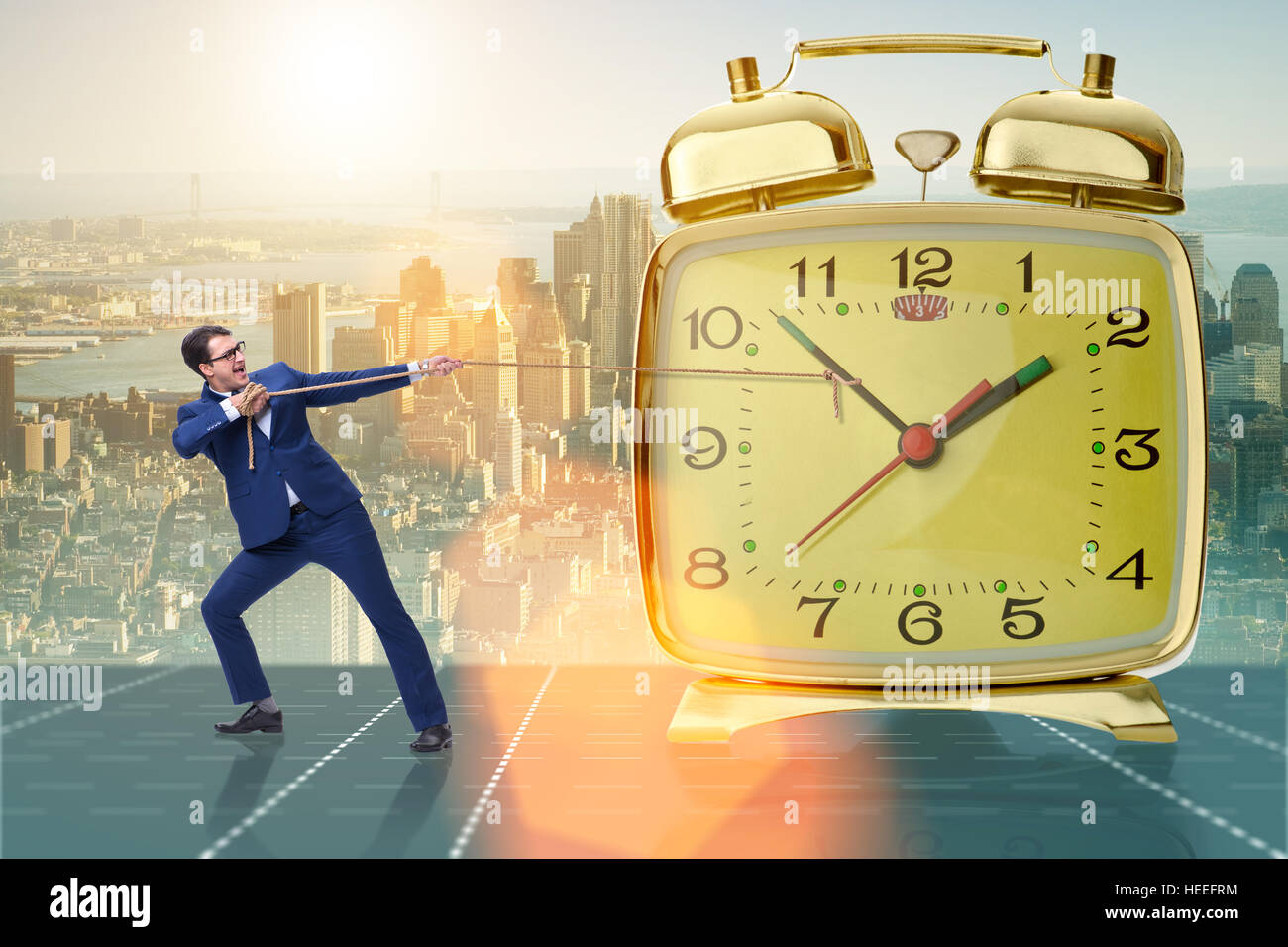 Businessman pulling clock in time management concept Stock Photo - Alamy