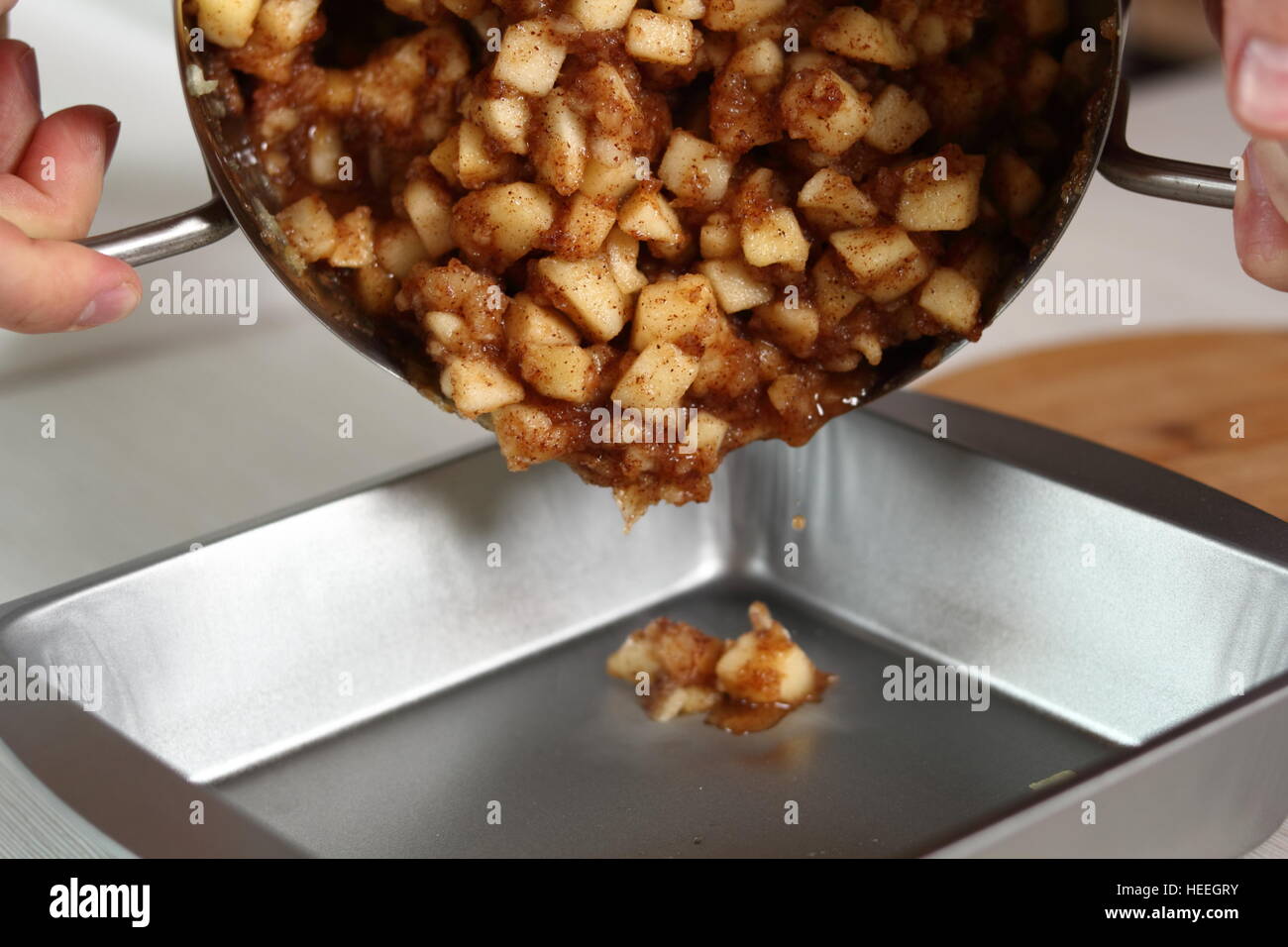 Pouring apple filling into baking pan. Making Filo Pastry Topped Apple ...
