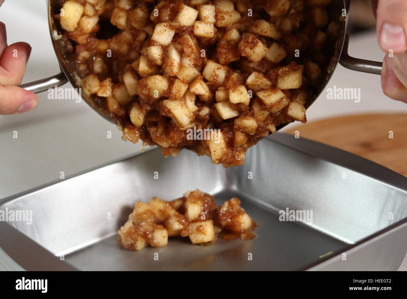 Pouring apple filling into baking pan. Making Filo Pastry Topped Apple ...