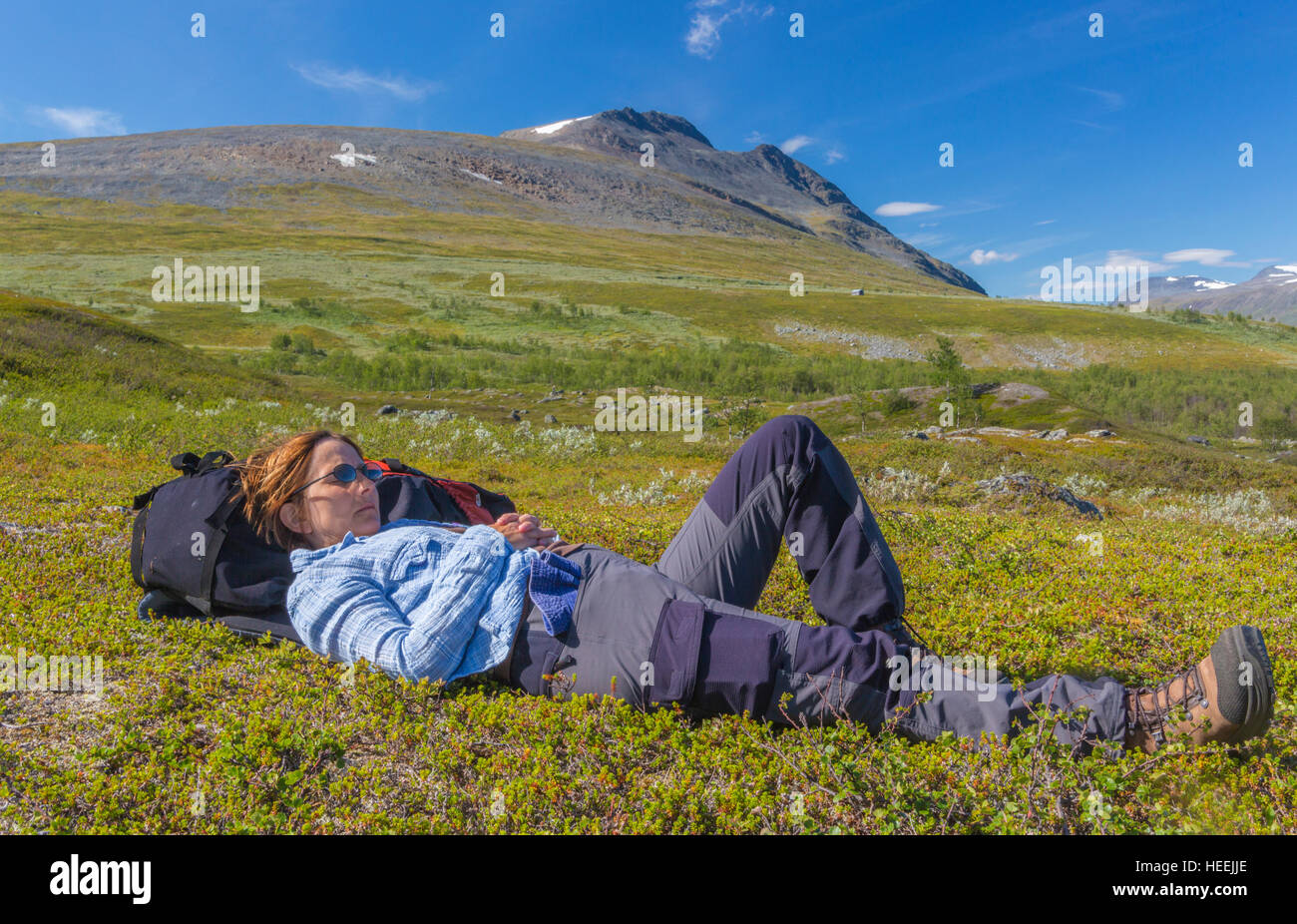 Woman hiking taking a rest, lying down, mountain in the background ...
