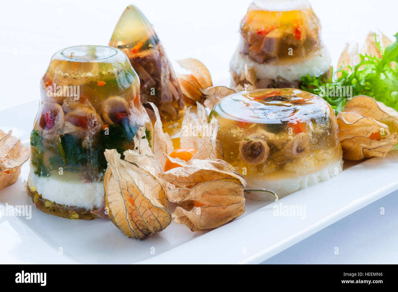 Decorated food. Aspic cold dish with meat, jelly, vegetables, greenery ...
